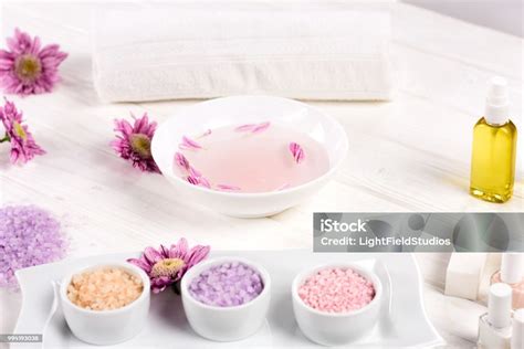 꽃 수건 매니큐어와 페디큐어 뷰티 살롱에 대 한 다채로운 바다 소금 손톱 벗어나게 및 아로마 오일 병 테이블에서 꽃잎으로 손톱을