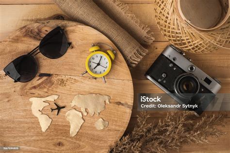 관광 필수품의 탑 뷰 복고풍 카메라 선글라스 황금 세계 지도 옆에 있는 여권 나무 배경에 있는 비행기 실루엣 여행자 액세서리가