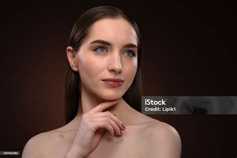 긴 머리와 맨어깨를 가진 아름다운 여자의 초상화를 구성하지 않습니다 매력적인 갈색 머리 모델 소녀 포즈 에 카메라 터치 그녀의 턱 와 A 손가락 고립 된 에 검정 배경 갈색