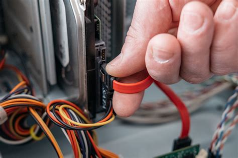 남자의 손은 하드 드라이브 장치에 Sata 데이터 케이블을 연결 합니다 컴퓨터 버스 인터페이스로 대용량 저장 장치를 연결 하 고