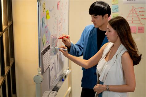 똑똑한 비즈니스 남자와 예쁜 여자는 자신의 프로젝트를 계획하는 화이트 보드에 펜 쓰기를 사용 남자에 대한 스톡 사진 및 기타