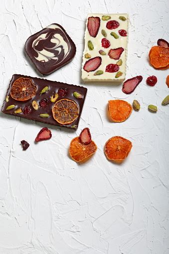 홈메이드 화이트와 블랙 초콜릿 말린 오렌지 딸기 체리 피스타치오 조각으로 장식되어 있습니다 표면에 장식 석고 흰색으로 덮여 0명에 대한 스톡 사진 및 기타 이미지 Istock