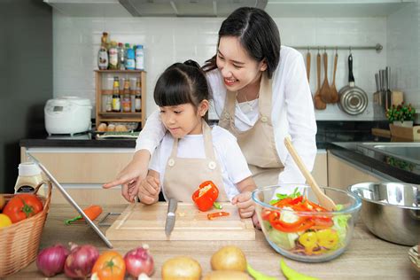 Asian Mother And Her Daughter Enjoy Cooking Togather Photograph By Anek