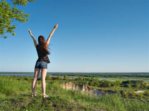 Una Ni A Est De Pie Con Los Brazos Levantados Hacia El Cielo Mujer Joven Relajada Mirando A La