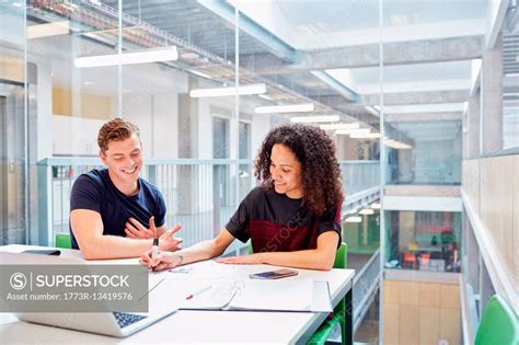 Male And Female Designers Brainstorming In Design Studio SuperStock