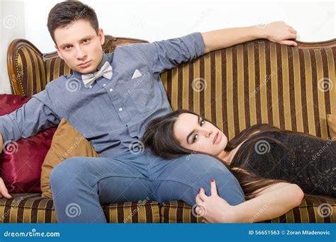 Attractive Couple At Ancient Room Sitting On Couch Or Sofa Stock Image