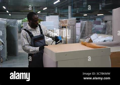 Furniture Workshop Worker Uses Electric Stapler To Attach Upholstery Fabric To Wooden Sofa Base