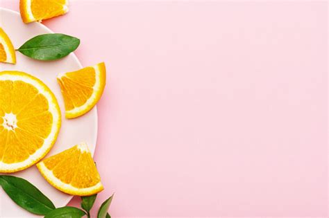 밝은 배경에 분홍색 접시에 잎이 있는 슬라이스와 조각이 있는 오렌지 비타민 C 최고 보기 복사 공간을 가진 육즙 감귤류 유기농 여름 과일 건강한 음식 0명에 대한 스톡 사진