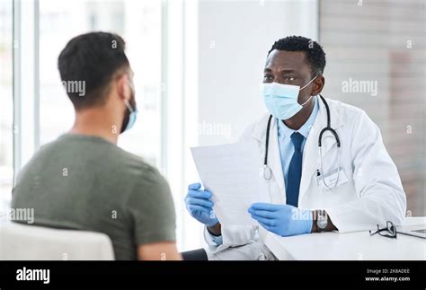 A Routine Checkup Is The Right Way To Go A Masked Doctor Having A Consultation With A Man Stock
