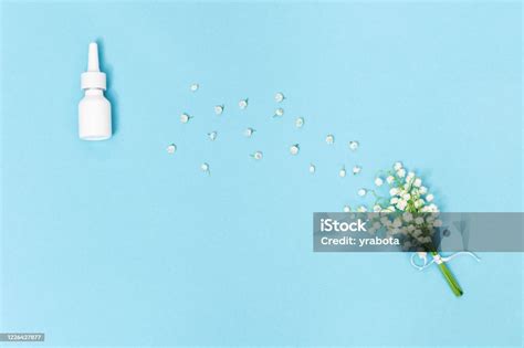 계절의 봄과 여름의 꽃이 피는 알레르기의 시작에 Ð 흰색 비강 스프레이와 향기로운 꽃 복사 공간이있는 파란색 배경에 창조적 인 평면 평신도 구성 개념에 대한 스톡 사진 및