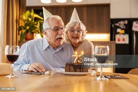 축제 노인 커플은 집에서 생일을 축하하고 생일 케이크에 촛불을 불고 있습니다 2명에 대한 스톡 사진 및 기타 이미지 2명 60 69세 70 79세 Istock