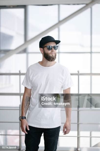 흰색 빈 티셔츠와 캐주얼 한 도시 스타일의 로고 또는 디자인을위한 공간이있는 야구 모자를 입은 수염이있는 힙스터 잘 생긴 남성 모델 공란에 대한 스톡 사진 및 기타 이미지