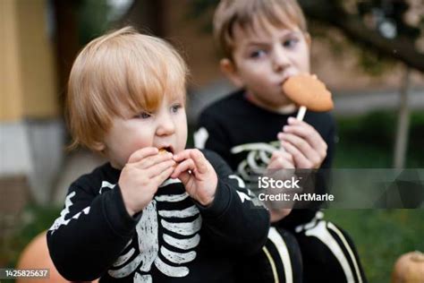 귀여운 아기 소녀와 해골 의상을 입은 어린 소년은 할로윈 과자를 먹는다 할로윈에 대한 스톡 사진 및 기타 이미지 할로윈 아이 사탕 Istock