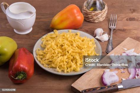 나무 테이블에 크림 파프리카 소스를 곁들인 파스타 만들기 위한 재료 피망 접시에 파스타 크림 주전자 다진 양파 0명에 대한 스톡 사진 및 기타 이미지 Istock