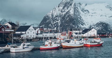 노르웨이 로포텐 제도의 함노이 어촌 마을에 배가 있는 부두와 겨울에 빨간 로부 가옥이 있습니다 사진 Unsplash의 노르웨이 이미지