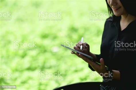 정원에서 스타일러스 펜으로 디지털 태블릿을 사용하는 여성의 공간을 복사합니다 20 24세에 대한 스톡 사진 및 기타 이미지