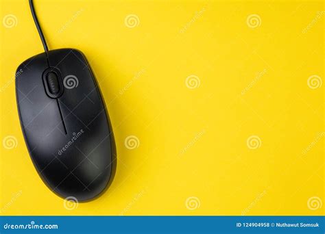 Black Computer Mouse With Scroll Wheel And Cord On Yellow Table Stock
