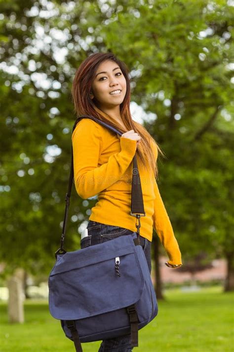 Estudiante Universitario De Sexo Femenino Con Los Libros Que Gesticula Los Pulgares Para Arriba