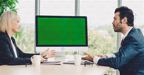 사무실 테이블에 녹색 스크린 크로마 키 Tv 또는 컴퓨터가 있는 회의실의 비즈니스 사람들 화상 회의에서 만나는 사업가와