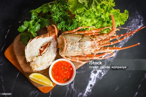 접시에 가시 랍스터 음식 신선한 랍스터 또는 바위 랍스터 허브와 향신료를 곁들인 해산물 레몬 고수풀 파슬리 양상추 샐러드 음식 요리용 랍스터 및 해산물 소스 식사 음식에