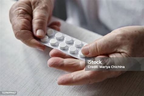 알약을 복용 슬픈 노인 노년기의 건강 문제 비싼 약물 노인 여성의 손은 약을 복용하기위한 여러 약을 풀고 할머니는 태블릿을 가지고 물 한 잔을 마십니다 개선에 대한 스톡