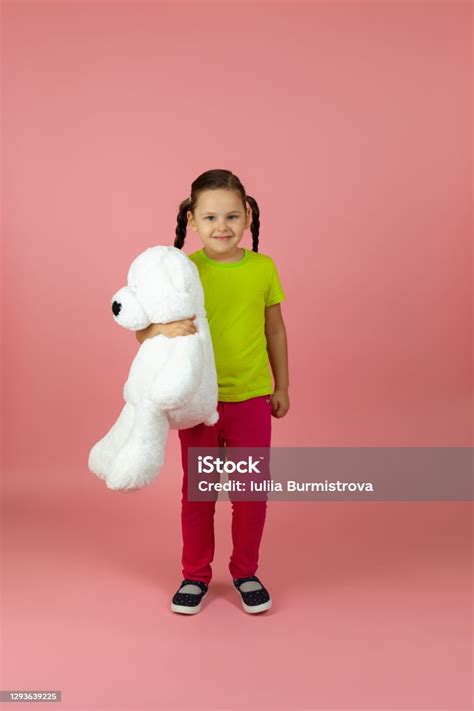 밝은 녹색 티셔츠와 빨간 바지에 전체 길이 만족 행복한 피그 테일 소녀는 분홍색 배경에 고립 된 흰색 테디 베어를 보유하고 2월에 대한 스톡 사진 및 기타 이미지 Istock
