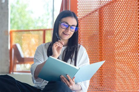 Young Woman With Glasses And Notebook In Modern Interior Study Concept