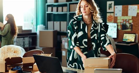 상자 노트북 및 물류 배달 또는 배송 일정을 위해 사무실에서 여성과 함께 전자 상거래 추적을 위해 창고 또는 창고에 있는 심각한 택배 담당자가 있는 컴퓨터 온라인 주문 및