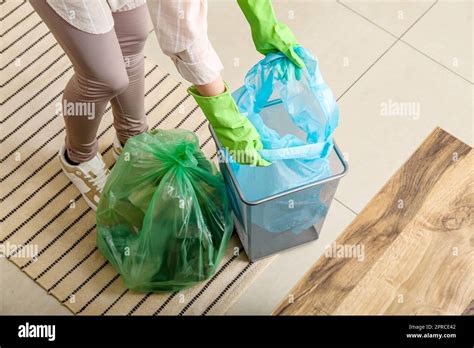 Woman In Rubber Gloves Placing Garbage Bag Into Trash Bin In Kitchen Stock Photo Alamy