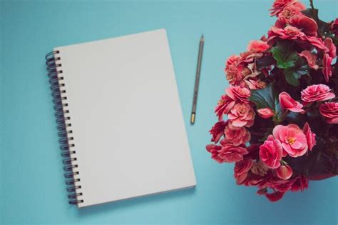Premium Photo Notepad On A Blue Background With Pink Flowers