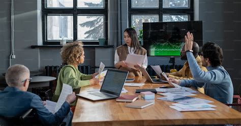 회의에서 프레젠테이션 또는 프로젝트 요점에 대해 논의하는 동안 동료 중 한 명과 이야기하는 논문을 가진 젊은 아시아 사업가 사진 Unsplash의 실내 이미지