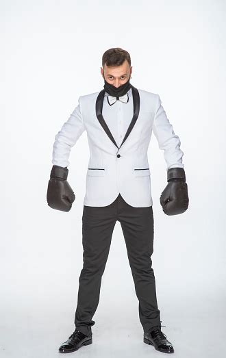활 넥타이가있는 흰색 양복을 입은 권투 선수가 싸운다 하얀 재킷 블랙 복싱 장갑 검은 의료용 마스크를 입은 남자가 고립된 흰색