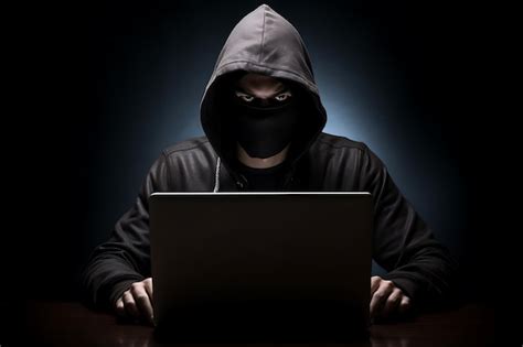 Premium Photo Hooded Computer Hacker Stealing Information With Laptop