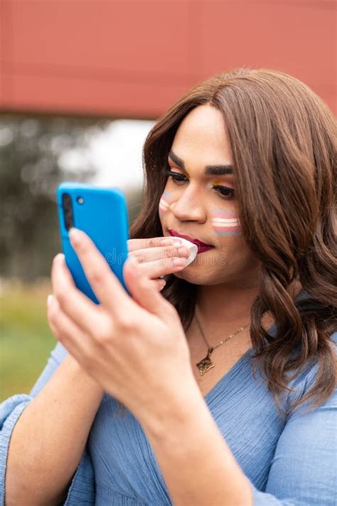 Young Trans Woman Removing Make Up And Using Cellphone As Mirror Lgtb