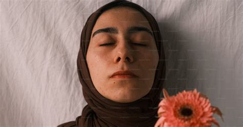 히잡을 쓴 여자가 꽃을 들고 있다 사진 Unsplash의 여성 이미지