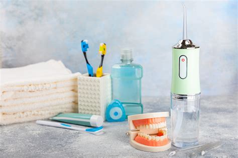 파란색 배경에 전자 구강 세정기 칫솔 페이스트 치실 및 구강 세정제 구강 위생을위한 치과 도구 전기 치간 청소기 치과용 물 샤워 구강 관리 개념입니다 0명에 대한 스톡 사진