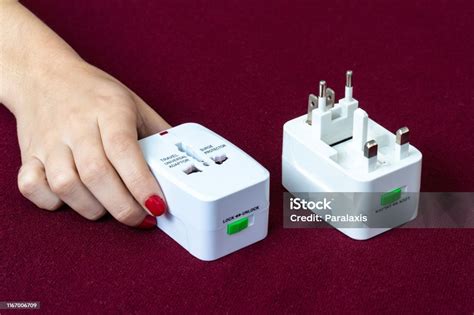 여행에 사용되는 범용 전기 소켓 플러그 어댑터를 닫습니다 전 세계 여러 전기 콘센트에 연결하는 데 사용됩니다 어두운 배경에 격리 된 전기 어댑터 배터리 충전기에 대한 스톡