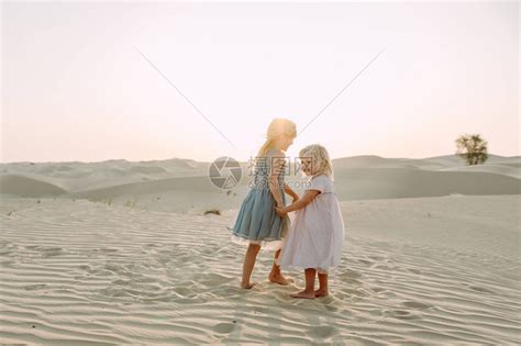 两个小女孩在迪拜沙漠丘上高清图片下载 正版图片504008743 摄图网