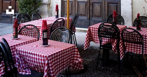 우산 아래에 빨간색과 흰색 체크 무늬 식탁보가 있는 테이블 사진 Unsplash의 무료 이탈리아 이미지