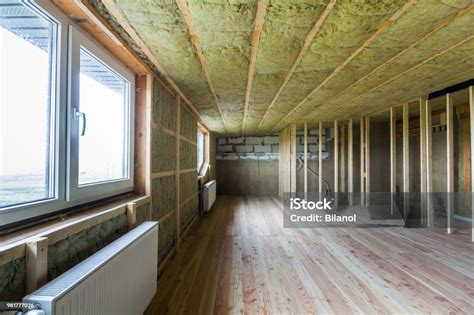 건설과 오크 바닥 벽과 천장 바위 모직 미래의 벽에 대 한 낮은 다락방 창과 목조 프레임 아래 라디에이터 난방과 절연 큰 빛 넓은 빈 룸의 리노베이션 0명에 대한 스톡 사진