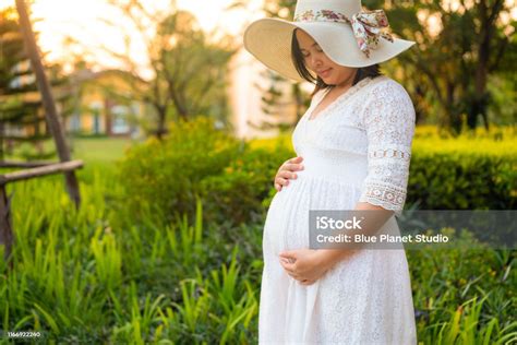 임산부는 아이를 돌보면서 정원에서 새로운 삶에 행복을 느낍니다 임신 한 배에 아기를 들고 젊은 기대 어머니 출산 전 관리 및 여성 임신 개념 개념에 대한 스톡 사진 및 기타