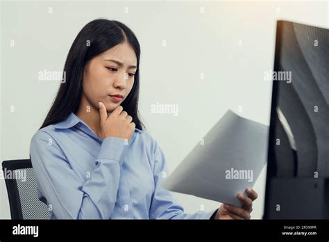 Concentrated Asian Woman Brainstorming While Coding Data On Desktop Pc While Working On Computer
