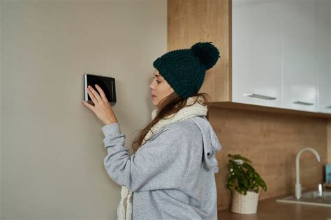Premium Photo Caucasian Woman Using Control Panel For Setting Higher Temperature At Home