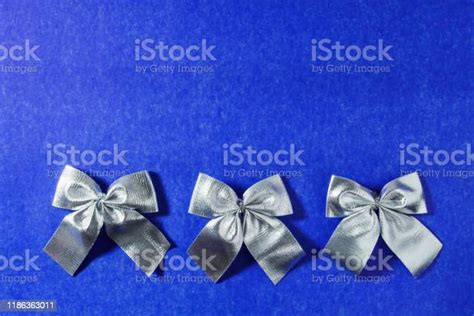 파란색 판지 배경에 세 개의 실버 장식 활 맨 위 보기 텍스트에 대 한 공간을 복사 합니다 0명에 대한 스톡 사진 및 기타 이미지 Istock