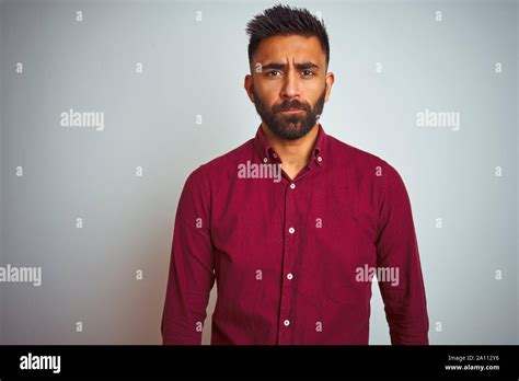 Young Indian Man Wearing Red Elegant Shirt Standing Over Isolated Grey