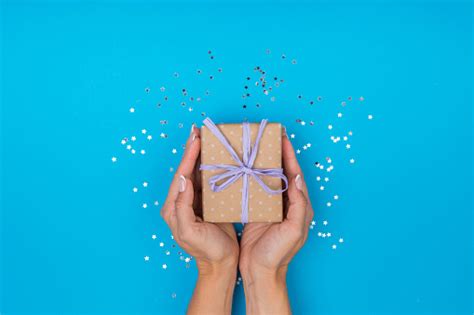 파란색 테이블 상단보기에 색종이로 장식 된 선물 이나 선물 상자를 들고 있는 여성 손 생일 이나 결혼식을 위한 플랫 구성 각도에 대한 스톡 사진 및 기타 이미지 Istock