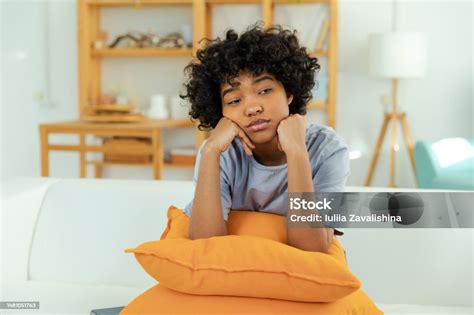 아프리카계 미국인 슬픈 사려 깊은 잠겨 있는 동기 부여되지 않은 소녀가 집 안의 소파에 앉아 있다 젊은 아프리카 여성은 긴 하루를 보낸 후 피곤해 보인다 소녀는 우울한