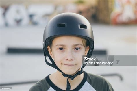 헬멧을 쓰고 카메라를 바라보며 스케이트 파크에서 트렌디한 젊은 스케이터의 초상화 스케이트 보드와 함께 도시에서 야외에서 화창한 하루를 즐기는 십대 청소년 행복 안전 스포츠