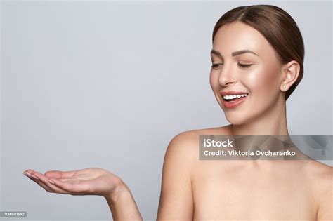 뷰티 스파는 완벽 한 피부를 가진 여자 아름 다운 미소 갈색 스파 소녀 텍스트 손 손바닥에 빈 복사본 공간을 보여주는 제품을