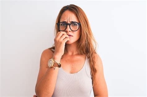 젊은 빨간 머리 여자는 흰색 고립 된 배경 위에 서 안경을 입고 스트레스와 손톱을 물고 손에 긴장 찾고 불안 문제 감정에 대한 스톡 사진 및 기타 이미지 Istock